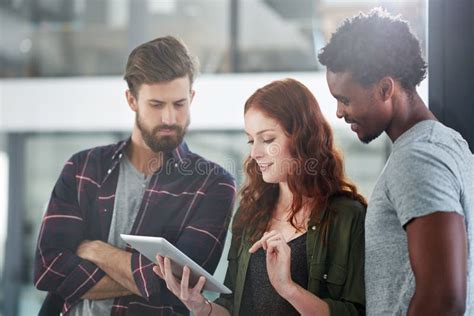 Finding Solutions Online As A Team Three Young Creatives Working Together On A Digital Tablet