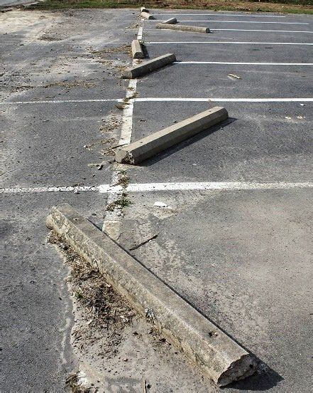 Lateral Movement Of Several Unanchored Concrete Parking Stops In Front