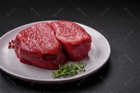Bife De Filé Mignon Cru Com Sal Especiarias E Ervas Em Um Fundo Escuro