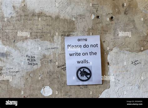 an ironic sign on the wall of the historic cork city gaol that reads please do not write on the