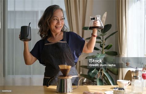 편안한 가정 부엌에서 아침 식사를 위해 커피를 준비하는 행복한 성숙한 여성 은퇴 건강한 노인 생활 방식 활동적인 노인에 대한