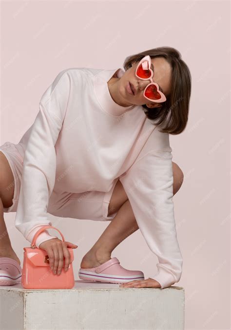 красивая кавказская молодая женщина позирует в розовой спортивной одежде с розовыми аксессуарами