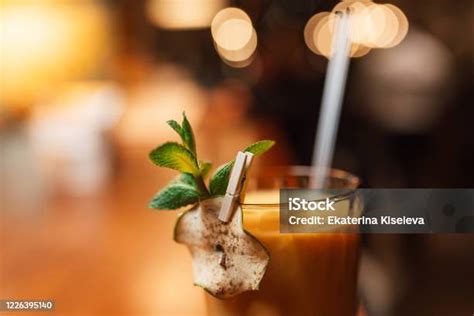 바 카운터에서 민트와 말린 과일로 장식된 투명한 유리에 매력적인 오렌지 칵테일이 있습니다 배경의 흐릿한 조명 다른 초점 클로즈업 0명에 대한 스톡 사진 및 기타 이미지