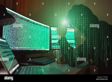 Cyber Crime Side View Of Young Hacker In Black Hoodie Using Multiple Computers And His