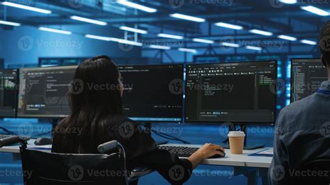 Woman With Impairment Next To Diverse Coworkers In Data Center Coding