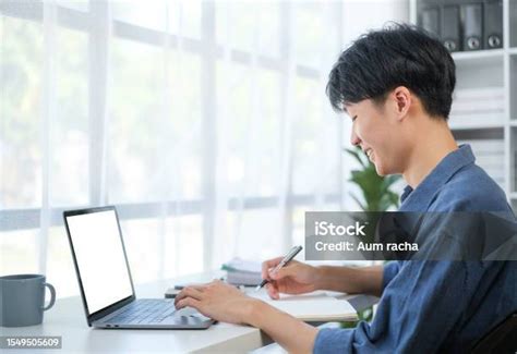 만족한 젊은 사업가가 종이에 전략을 쓰고 사무실 책상에서 노트북을 사용한다 20 24세에 대한 스톡 사진 및 기타 이미지 20 24세 30 34세 개성 개념 Istock