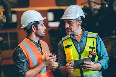 건설 현장의 팀워크 남자들 안전 헬멧 안전모를 쓴 두 명의 토목 기사 또는 전문 감독이 산업 공장에 서서 일하는 동안 디지털 태블릿에서 청사진을 사용하고 팀워크 개념 25