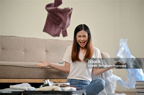A Crazy Asian Girl Throws Her Clothes Up In The Air While Packing Her