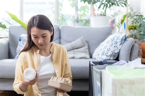 아시아의 젊은 여성이 집에 앉아 종이와 플라스틱 쓰레기를 분리하고 있다 재활용을 위한 쓰레기 분류 지구 온난화 감소 35 39세에 대한 스톡 사진 및 기타 이미지 Istock