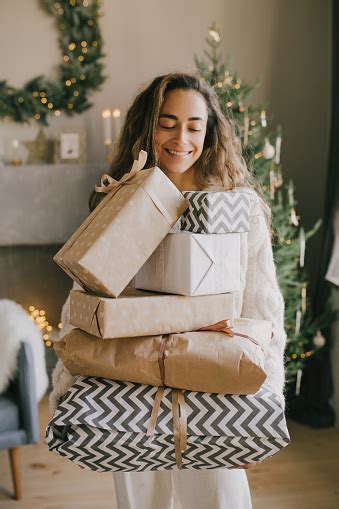 선물 상자와 선물을 들고 젊은 아름다운 여자는 배경에 크리스마스 트리와 아늑한 방에 선물 휴일 준비 30 34세에 대한 스톡 사진 및 기타 이미지 Istock