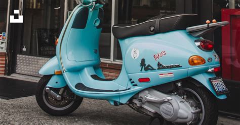 야간에 상점 옆에 주차 된 파란색과 흰색 모터 스쿠터 사진 Unsplash의 무료 벽지 이미지