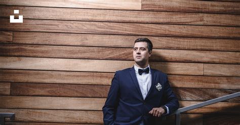 나무 벽에 기대어 양복을 입은 남자 사진 Unsplash의 무료 의류 이미지