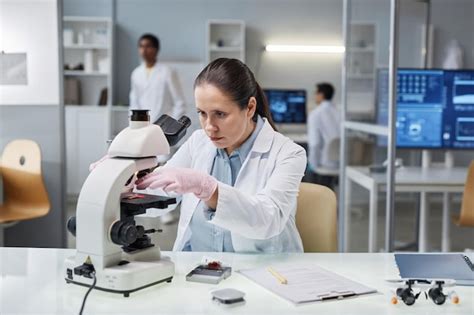Premium Photo Woman Scientist Putting Test Material In Microscope In Laboratory