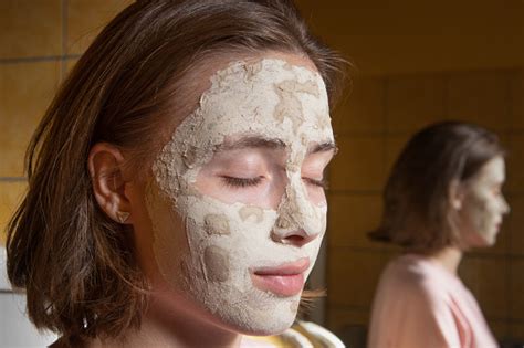 젊은 여성 모델의 클로즈업 초상화는 검은 색 배경에 집에서 만든 얼굴 점토 마스크를 적용합니다 건강관리와 의술에 대한 스톡 사진 및 기타 이미지 Istock