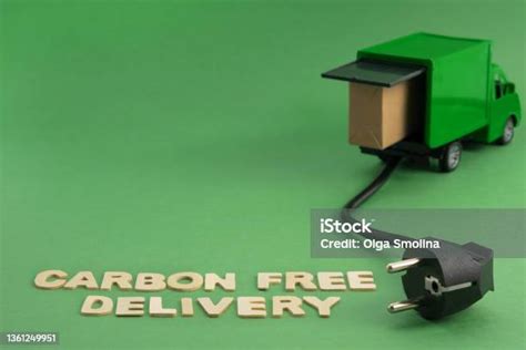 장난감 트럭 전기 플러그와 자동차 휴대 상자 상자 탄소 무료 배출 전달 솔루션 연료 전기 자동차 트럭 나무 편지 녹색 배경에 단어 위쪽 뷰 복사 공간 0명에 대한 스톡 사진