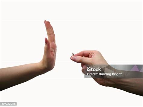 두 개의 고립 된 손 흰색 배경에 금색 반지를 들고있는 남자 손에 대한 움직임을 멈추는 긴 잘 다듬어진 손톱을 가진 여성의 손 결혼 제안과 거절의 제스처로 남성과 여성의 손