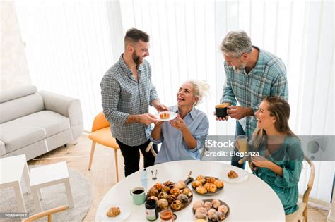 실내에서 함께 식사하는 행복한 가족 아침 식사 중에 식탁에 앉아 웃는 세대 가족 거실에서 함께 식사를 즐기는 행복한 쾌활한 가족 4 명에 대한 스톡 사진 및 기타 이미지