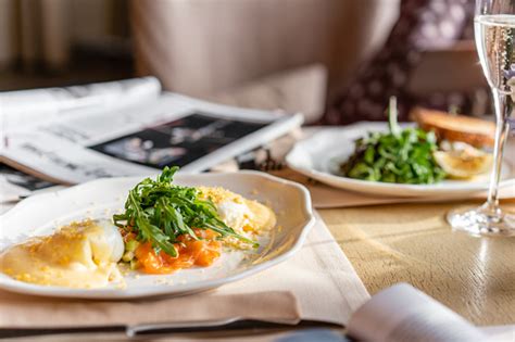 연어와 아루굴라와 접시에 작은 샐러드와 계란 베네딕트 계란 두 가지 맛있는 홀란다이즈 소스 레스토랑에서 테이블에 가벼운 아침 아침 식사 건강한 생활방식에 대한 스톡 사진 및