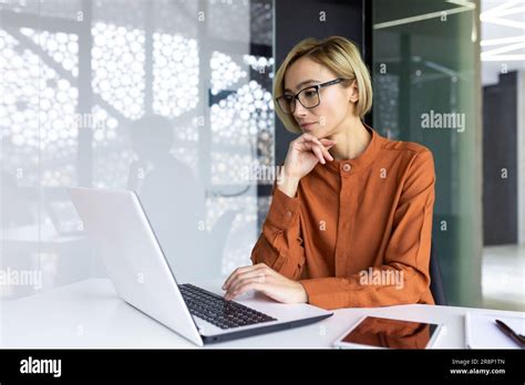 Serious Thinking Woman Working With Laptop Inside Office At Workplace Businesswoman Solving