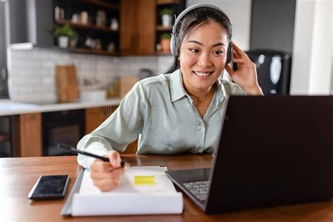 Young Asian Woman Working From Home Sitting In Front Of Laptop