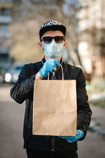 보호 마스크에 택배 의료 장갑테이크 아웃 음식을 제공합니다 직원은 골판지 패키지를 보유하고 있습니다 텍스트에 배치합니다 검역 2019ncov 전염병 코로나 바이러스