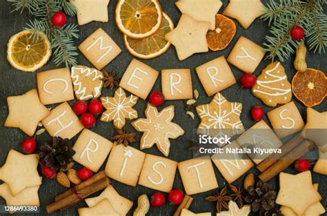 쿠키 메리 크리스마스로 만든 레터링 아이스 진저 브레드 쿠키 말린 오렌지 계피 별의 크리스마스 화환나무 배경에 집에서 만든 음식 백그룬 갈란드 장식품에 대한 스톡 사진 및