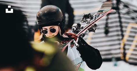 검은 재킷과 빨간 스카프를 입은 여자가 빨간색과 검은색 스노우 스키 블레이드를 들고 있다 사진 Unsplash의 무료 사람의 이미지