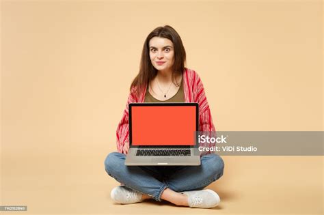 앉아 캐주얼 옷에 즐거운 젊은 여자 파스텔 베이 지 배경에 고립 된 빈 빈 화면으로 노트북 Pc 컴퓨터를 들고 사람들은 진심으로