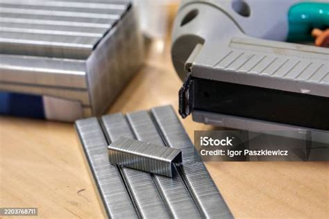 나무 표면에 스테이플 스트립이 있는 금속 스테이플 건을 클로즈업하여 실제 환경에서 도구 수리 및 Diy 프로젝트를 강조합니다 0명에 대한 스톡 사진 및 기타 이미지 Istock