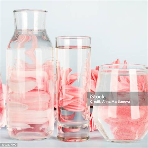 분홍색 꽃은 파란색 배경에 안경과 병에 물을 통해 왜곡 홈 장식 환경 친화적 인 휴식 원예 개념 복사 공간을 복사합니다 사각형 비현실적에 대한 스톡 사진 및 기타 이미지