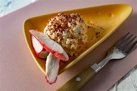 당근과 치즈를 공 모양으로 크랩 샐러드를 제공 부드러운 분홍색에 구멍치즈의 삼각형 조각의 형태로 흥미로운 접시에 말린 석류를 뿌려 0명에 대한 스톡 사진 및 기타 이미지