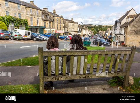 Jeunes Filles Assises Sur Un Banc Dos La Cam Ra Tout En Regardant En Bas De La Rue Photo