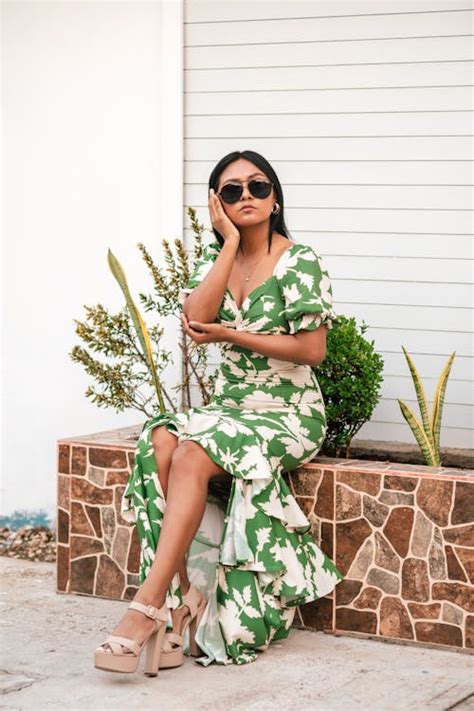 갈색 머리 거리 스타일 꽃 무늬 녹색 드레스 도시 설정 돌담 라이프스타일 롱 드레스 마음이 가벼운 모델 복각 뺨에 손을 대다 선글라스 수직 쐈어