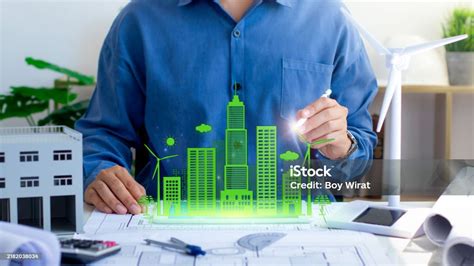 건축가는 청사진과 친환경 건물 모델로 둘러싸인 홀로그램 프로젝션을 사용하여 지속 가능한 도시를 설계합니다 친환경 건물 현대 도시 그린 비즈니스 지속 가능한 에너지 엔지니어에