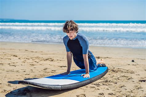 젊은 서퍼는 모래 해변에 라인업에 이동 하기 전에 훈련 남자 서핑을 학습 휴가 개념 여름 휴일입니다 관광 스포츠 건강한 생활