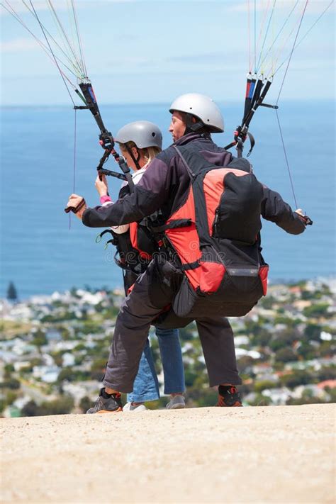 Just One Small Step To Freedom Rear View Of Two Paragliders Doing A Tandem Jump From The Edge