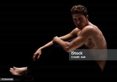 맨발로 맨발로 청바지바지시원한 자세를 입고 바닥에 앉아 바닥에 앉아 젊은 남성 2029 세 성인 잘 생긴 사람들의 한 남자 전체