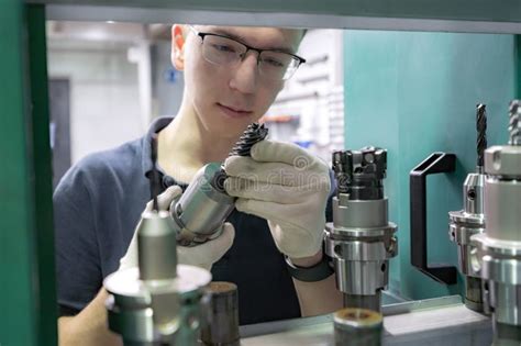 A Working Machine Operator Inspects A Cutter For A Cnc Machine From A