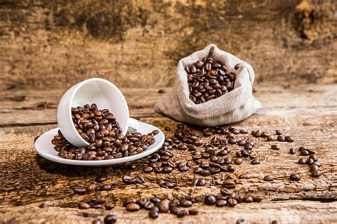 흰색 머그잔에 커피 콩입니다 나무 배경에 커피 콩입니다 커피 콩의 부 대입니다 어두운 배경입니다 0명에 대한 스톡 사진 및 기타