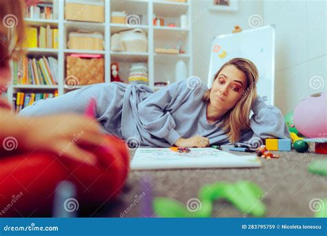 Madre Cansada Que Se Queda En Casa Cuidando A Su Hija Imagen De Archivo