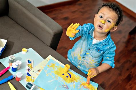 수채화로 그림을 그리는 동안 그의 다채로운 노란색 손에 놀란 카메라를 바라보는 소년의 초상화 2 3 살에 대한 스톡 사진 및 기타 이미지 Istock