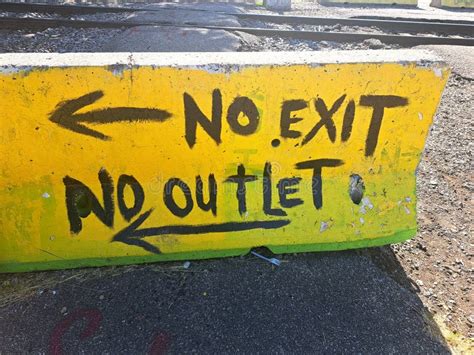No Exit No Outlet Painted On Yellow Concrete Block Black Graffiti Message With Arrows Dead End