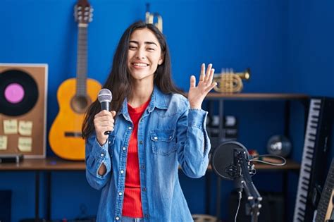 마이크를 사용하여 노래를 부르는 어린 십 대 소녀는 행복한 미소와 승자 표현으로 승리를 축하합니다 16 17 살에 대한 스톡 사진 및 기타 이미지 Istock