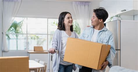 아시아의 젊은 행복한 새 결혼 부부가 함께 새 집으로 이사합니다 행복과 사랑으로 상자 소포와 여행 가방을 들고 매력적인 낭만적 인 남자와 여자 가족 이사 집 재배치 개념