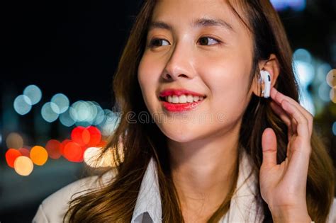 Young Woman Using Her Smartphone And Earphones To Stay Connected While