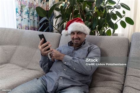 산타 클로스의 모자에 남자는 당신에게 전화로 새해 복많이 하고 메리 크리스마스를 기원합니다 12월에 대한 스톡 사진 및 기타 이미지 12월 겨울 공휴일 Istock