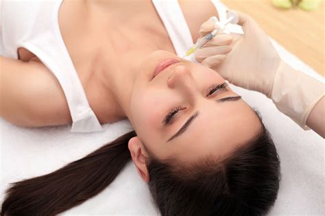 얼굴 입술에에서 주입 하는 미용사의 손 젊은 여자 얼굴 주사를 살롱에서 아름다움을 가져옵니다 얼굴 노화 회복 및 수 분 절차입니다 미적 화장품입니다 닫습니다 건강관리와