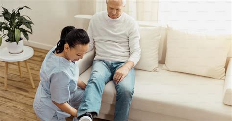 특별 운동 유쾌한 전문 경험이 풍부한 간병인은 한쪽 무릎에 앉아 특별한 심령 운동을하는 동안 환자 다리를 따뜻하게합니다 사진 Unsplash의 우크라이나 이미지