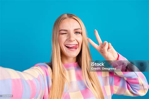 활기찬 파란색 배경에 평화의 표시와 제스처와 장난기 넘치는 표정으로 포즈를 취하는 쾌활한 젊은 여성은 캐주얼 트렌디 한 복장으로 행복과 긍정을 표현합니다 30 34세에 대한