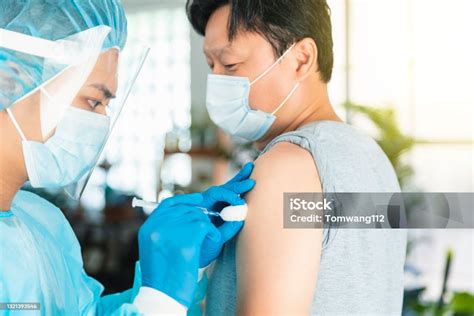 남성 환자에게 백신 주사를 하는 주사기로 바이러스 질환으로부터 보호하기 위해 얼굴 보호 의료 마스크를 착용한 의사가 20 24세에 대한 스톡 사진 및 기타 이미지 Istock